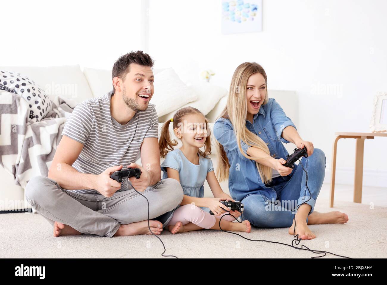 Happy family playing video games at home Stock Photo - Alamy