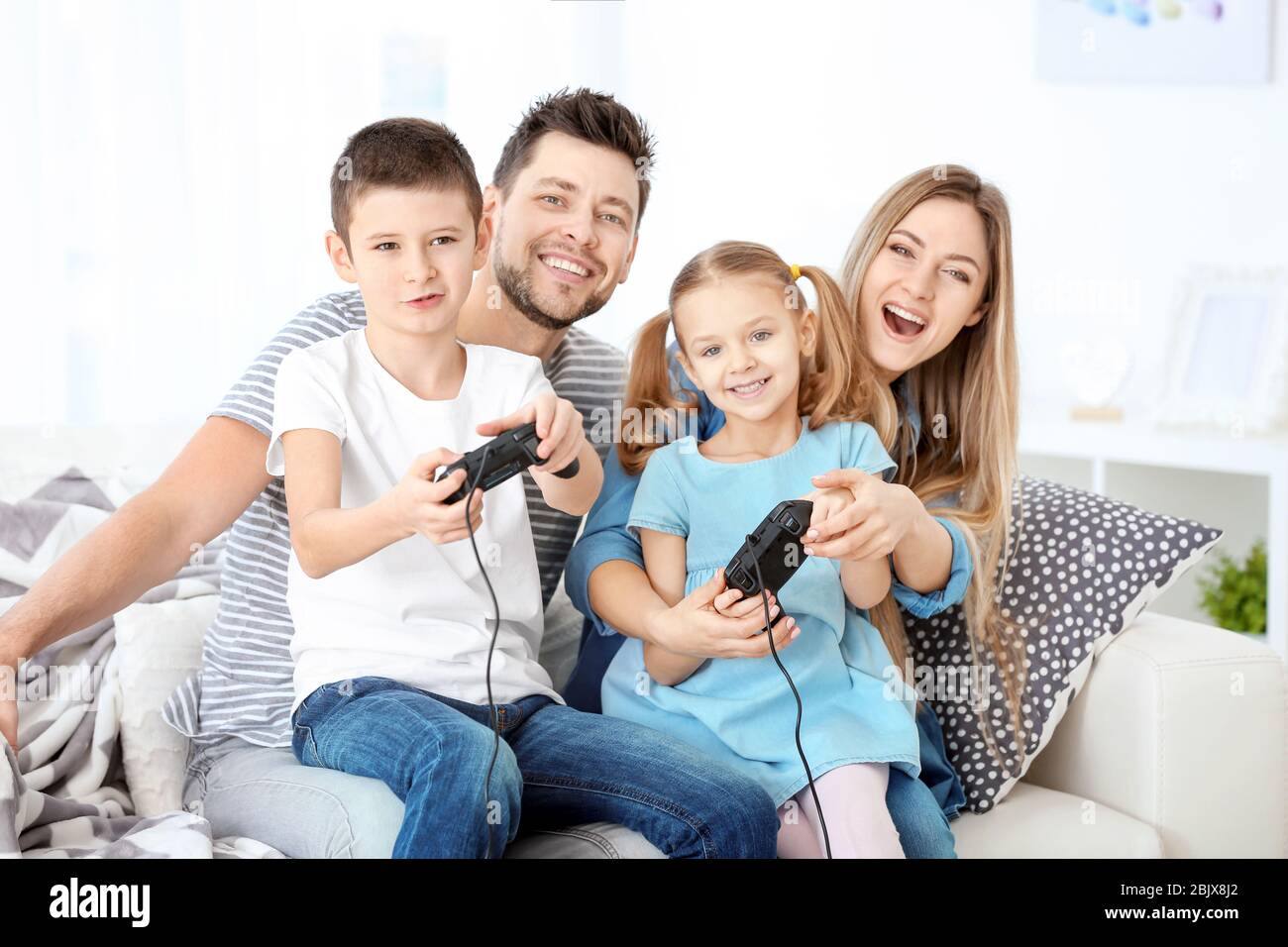 Happy family playing video games at home Stock Photo - Alamy