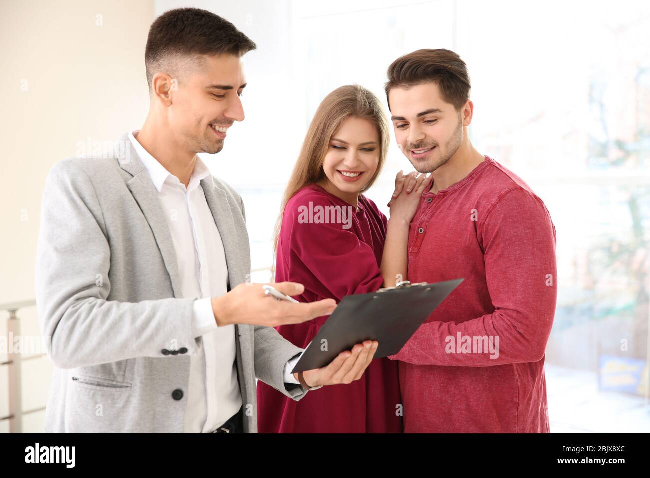 Real estate agent with clients in new house Stock Photo - Alamy