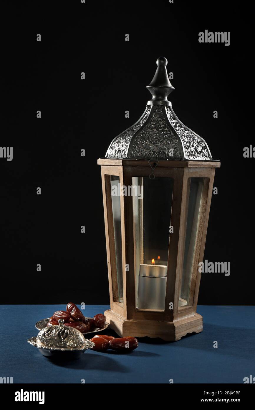 Composition with muslim lamp Fanous on table against dark background ...