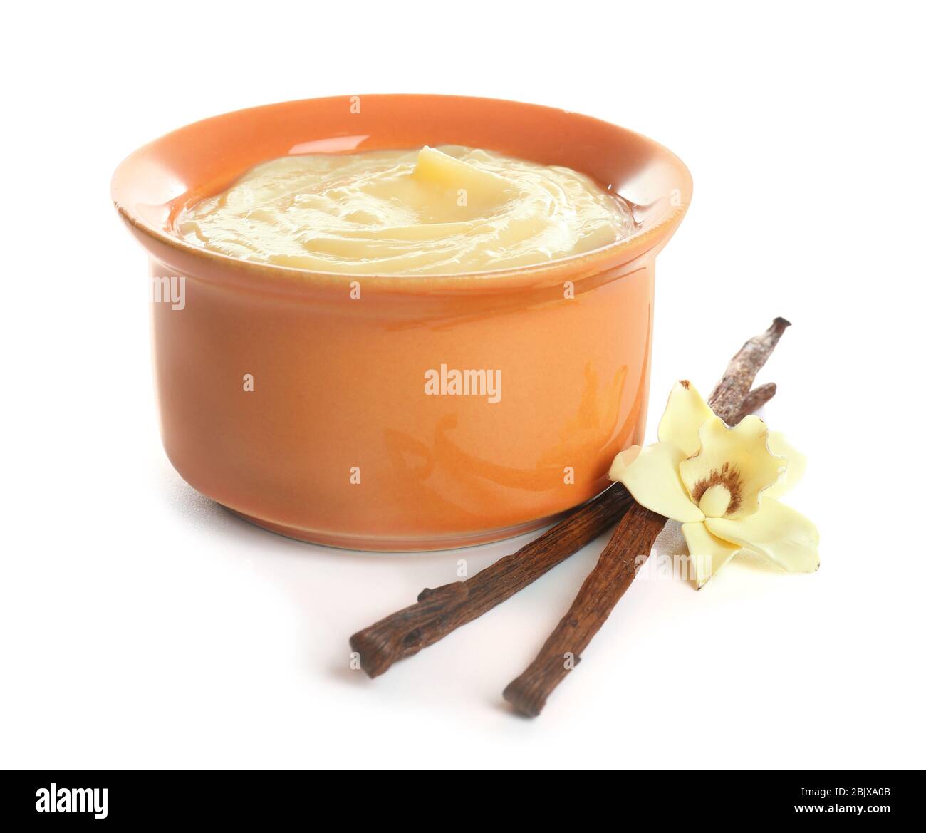 Tasty vanilla pudding in ramekin and sticks with flower on white ...