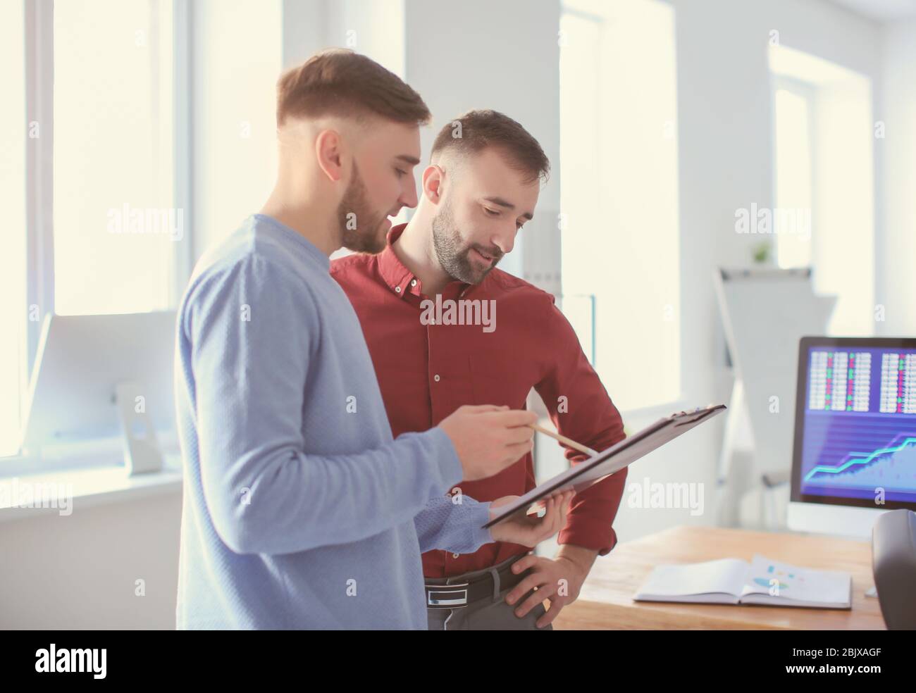 Young men working in office. Finance trading Stock Photo - Alamy