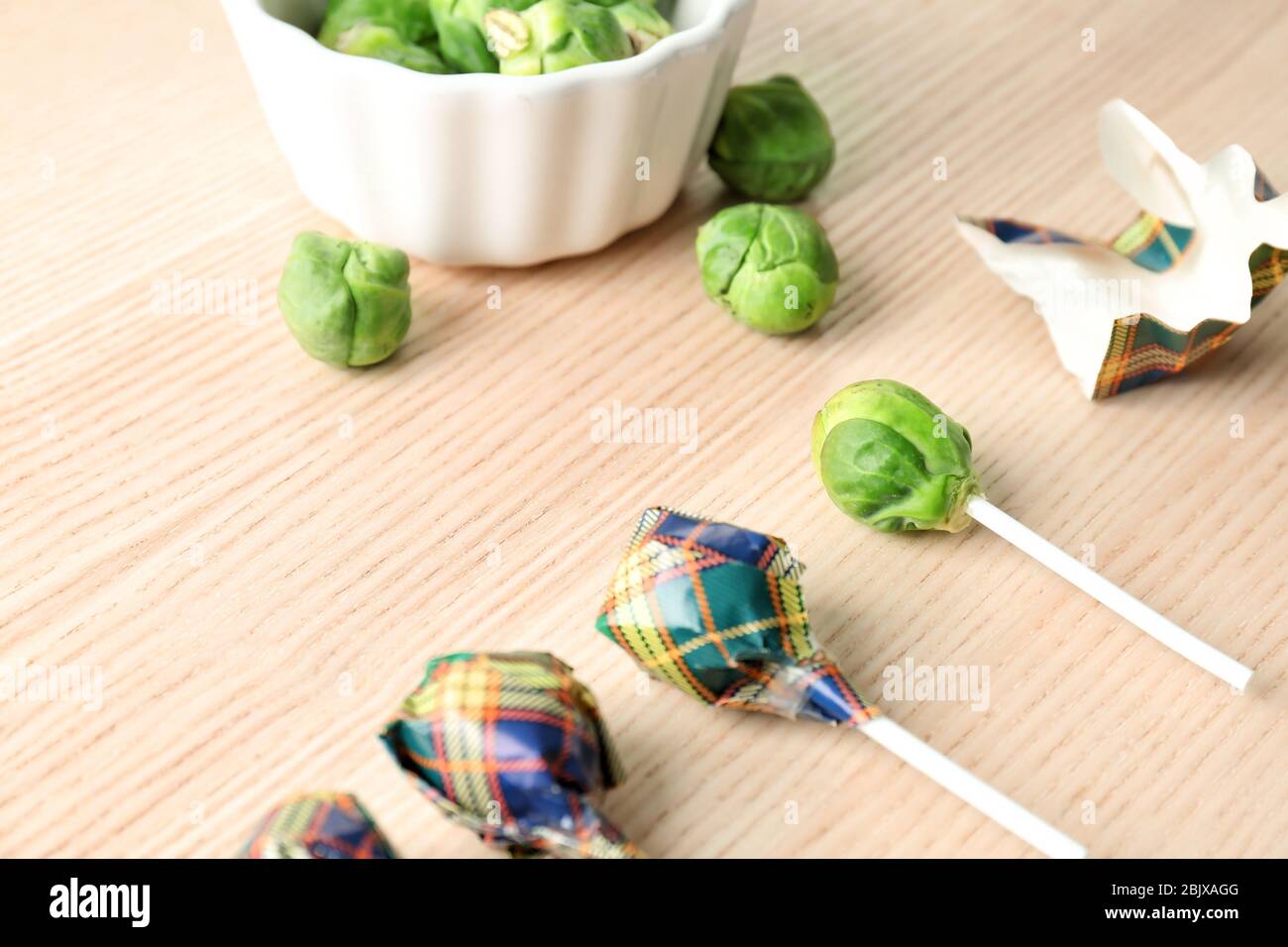 Brussel sprouts with lollipop sticks in candy wrappers on table. April ...