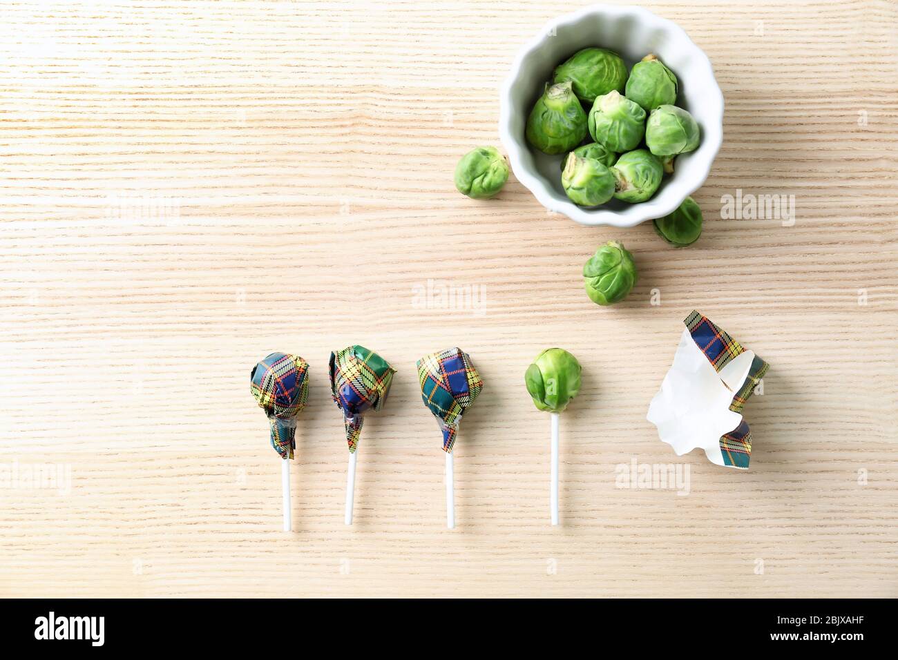 Brussel sprouts with lollipop sticks in candy wrappers on table. April ...