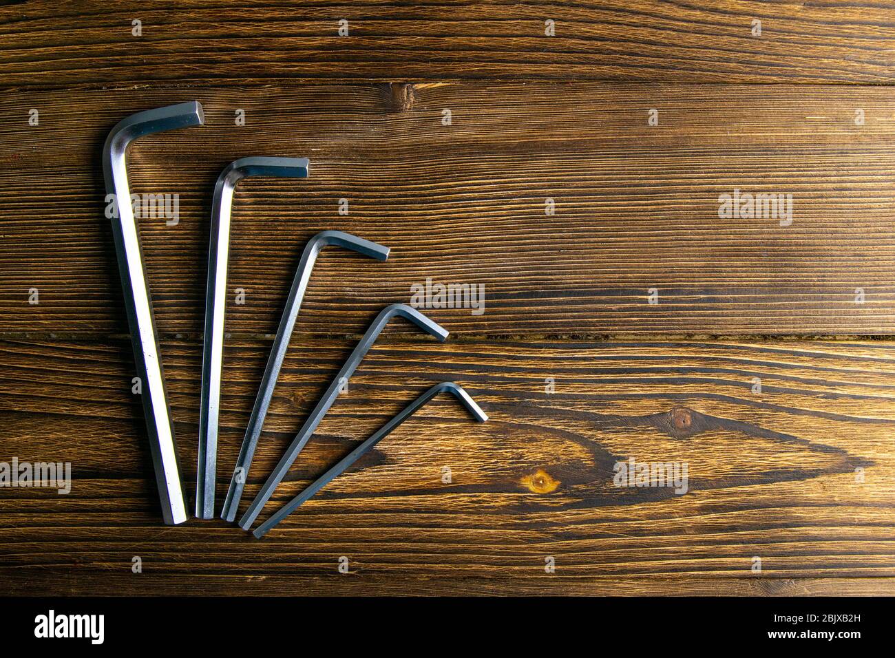 Set of hexagonal keys on a wooden table. Top view with clear space ...