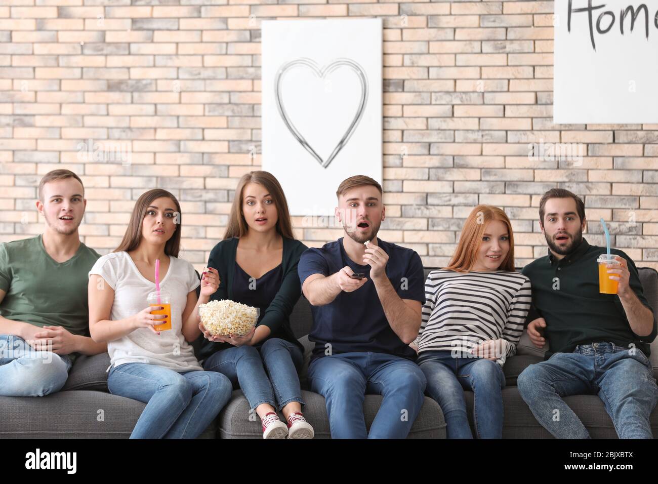 Young people watching TV at home Stock Photo - Alamy