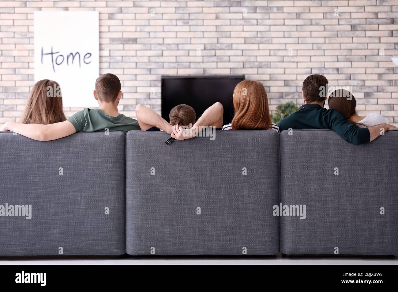 Young people watching TV at home Stock Photo - Alamy