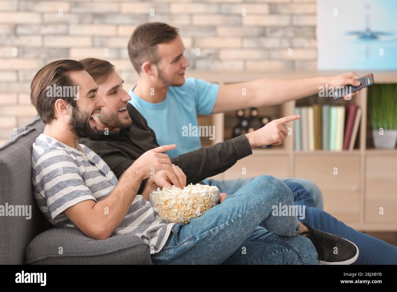 Young men watching TV at home Stock Photo - Alamy