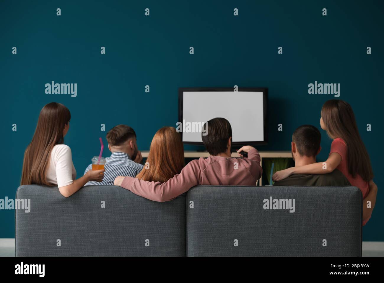 Young people watching TV at home Stock Photo - Alamy