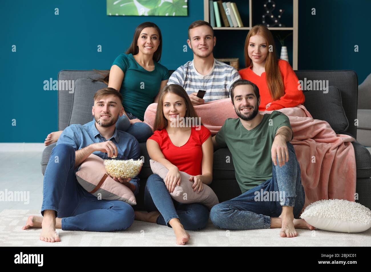 Young people watching TV at home Stock Photo - Alamy
