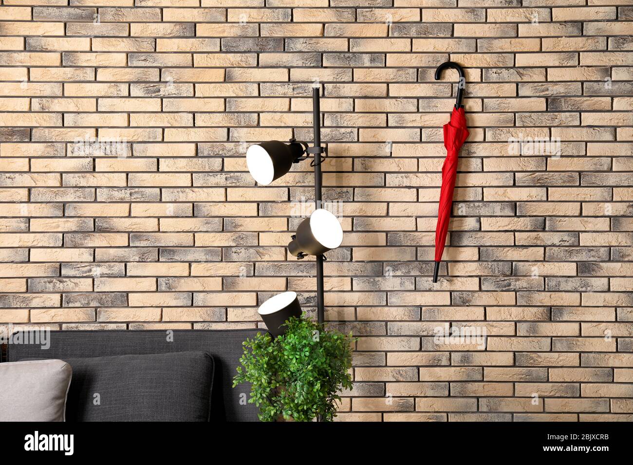 Stylish red umbrella hanging on brick wall Stock Photo - Alamy