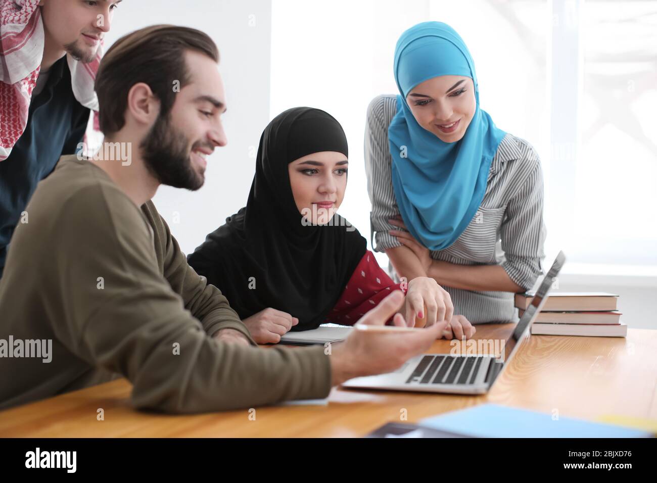 Male student and his Muslim classmates in library Stock Photo - Alamy
