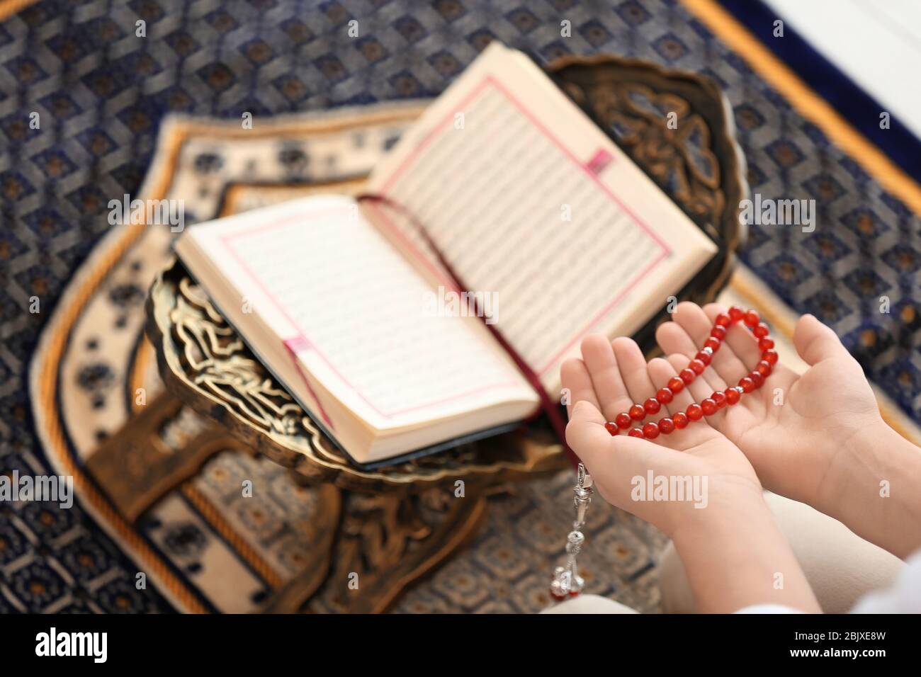 Young Muslim man with prayer beads making tasbih on rug, closeup Stock ...