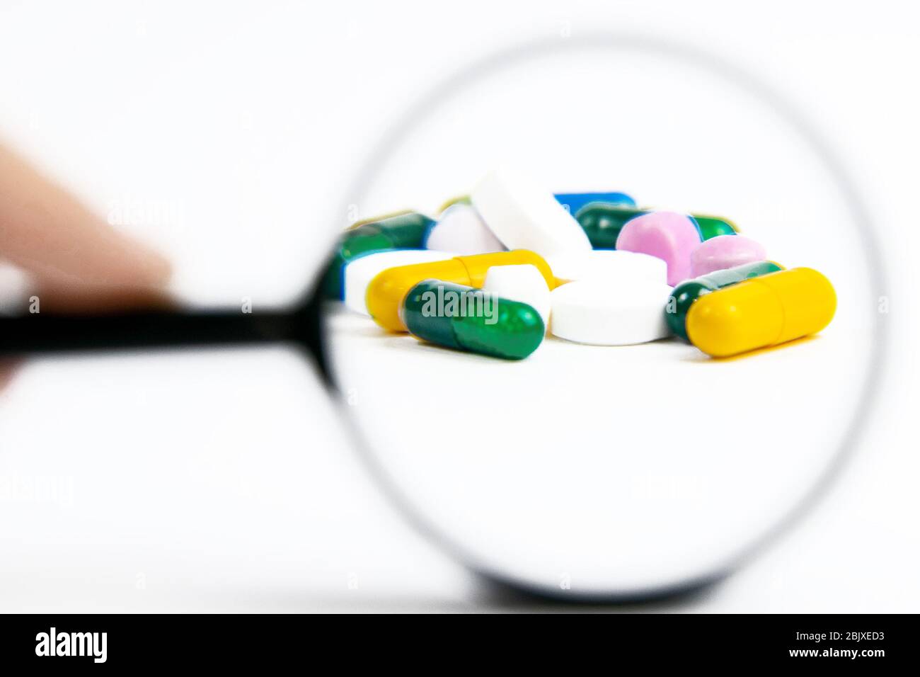 Zooming pills using magnifier glass. Special unique pills isolated on ...