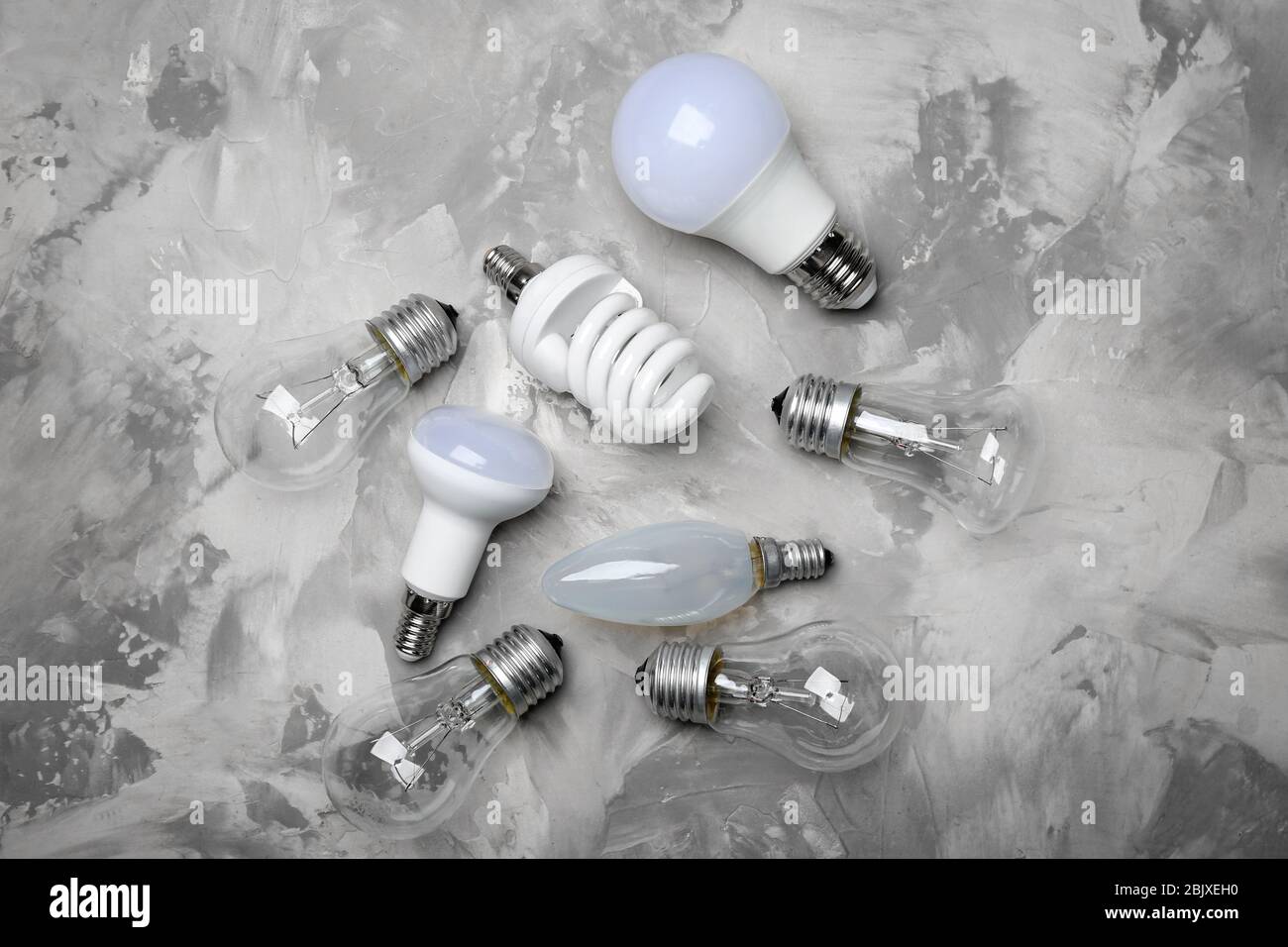 LED, incandescent and fluorescent lamps on grey background Stock Photo ...