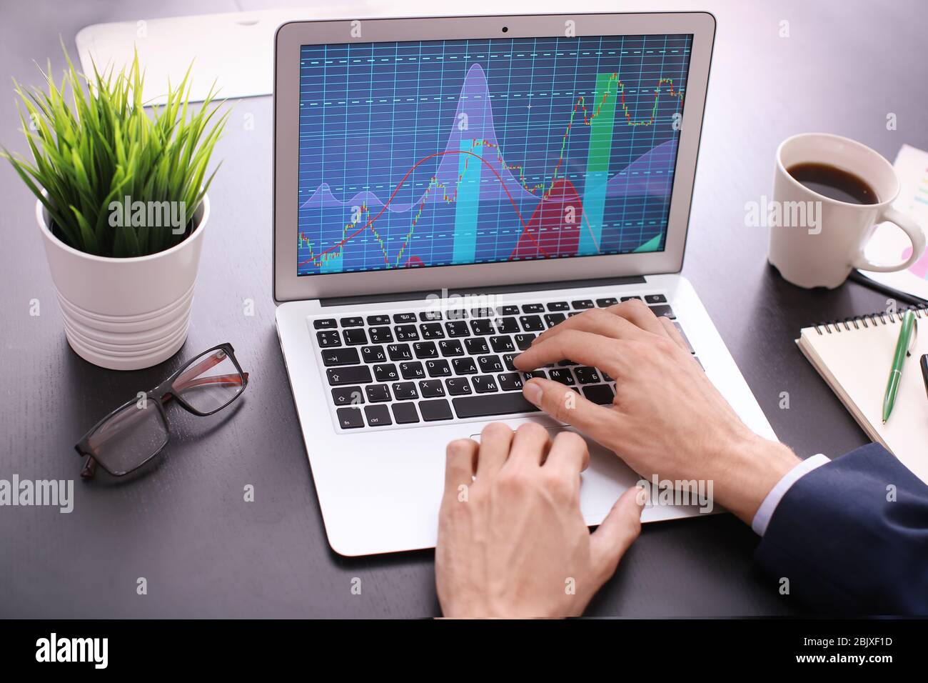 Man using laptop with stock chart data on screen. Forex concept Stock ...