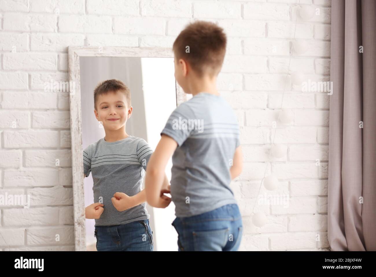 Cute little boy posing in front of mirror indoors Stock Photo - Alamy