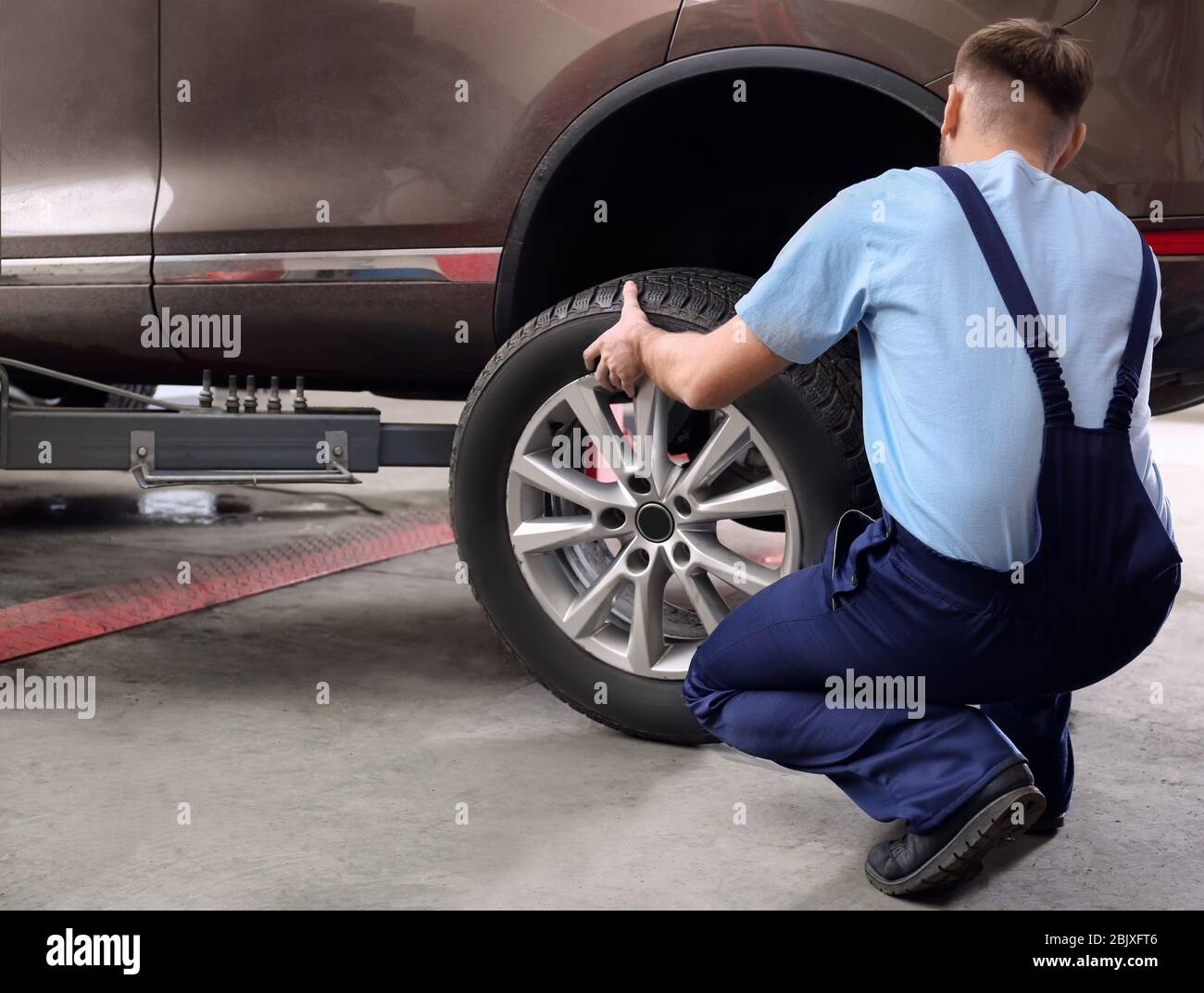 Mechanic changing car wheel in garage. Tire service Stock Photo - Alamy