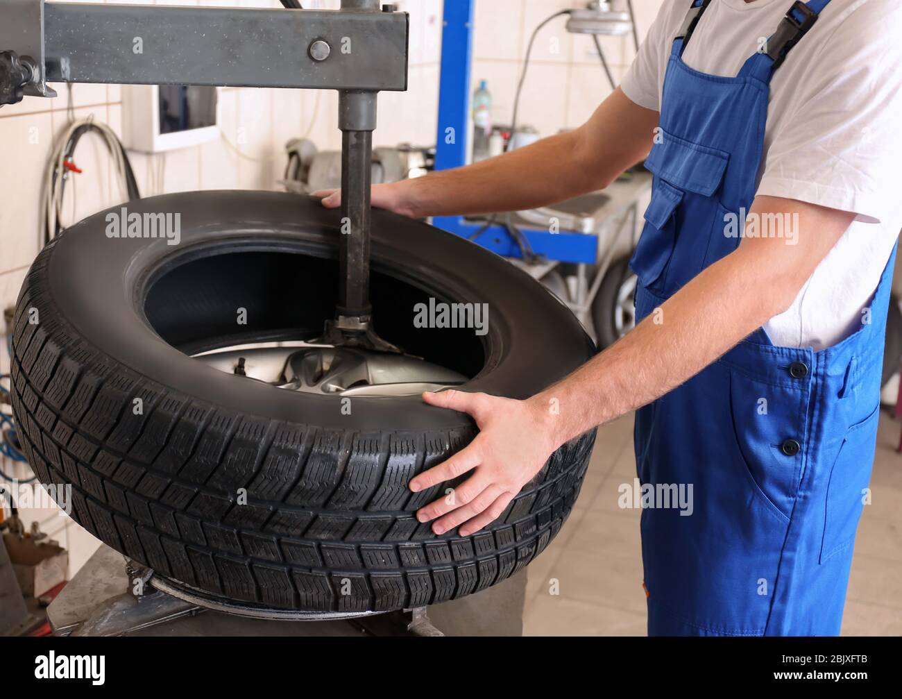 Mechanic changing car tire in service center Stock Photo - Alamy