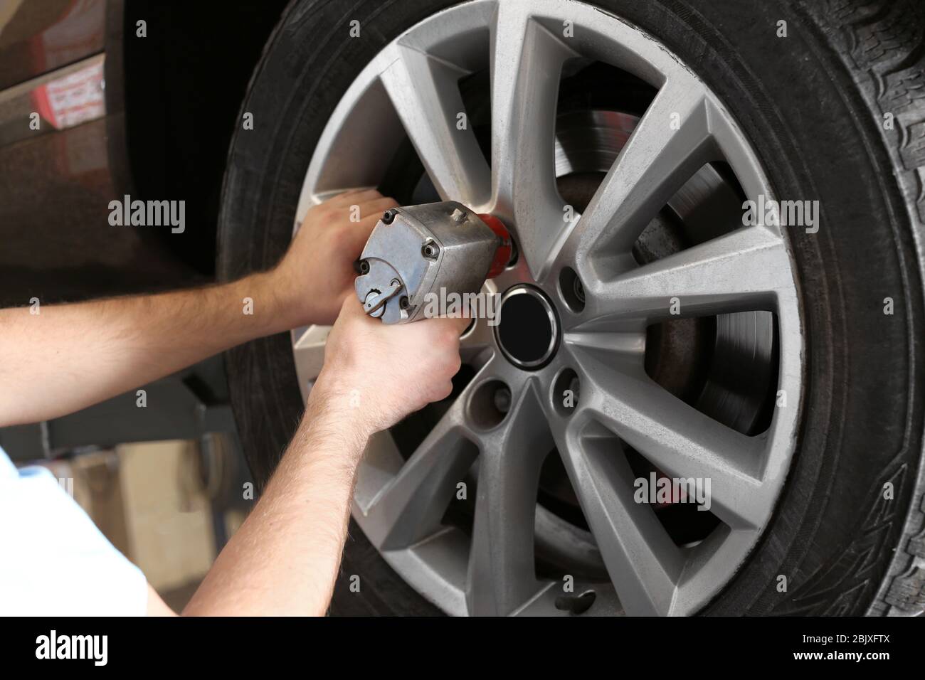 Mechanic changing car wheel in garage. Tire service Stock Photo - Alamy