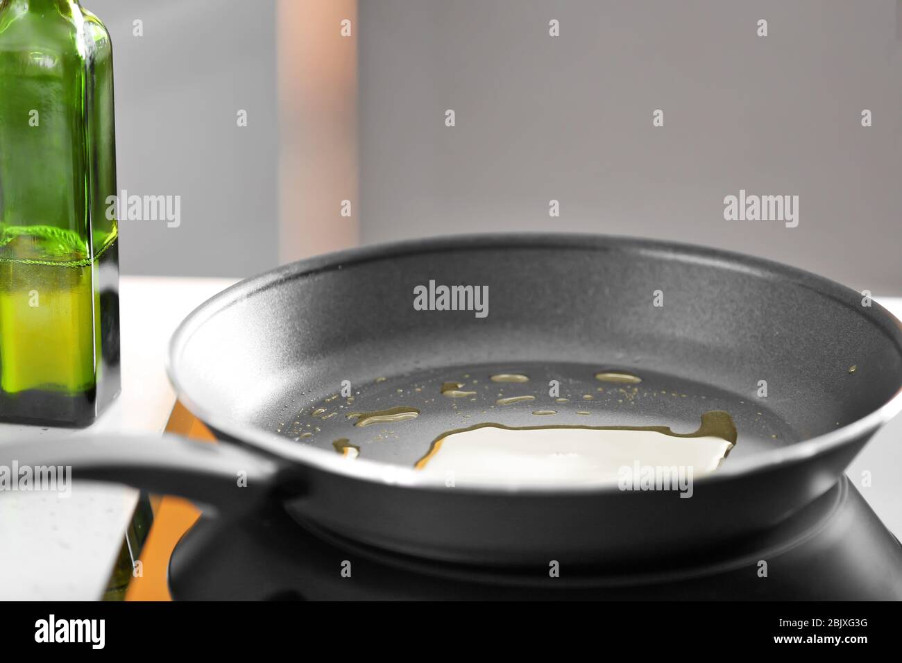 Frying pan with cooking oil on stove Stock Photo - Alamy