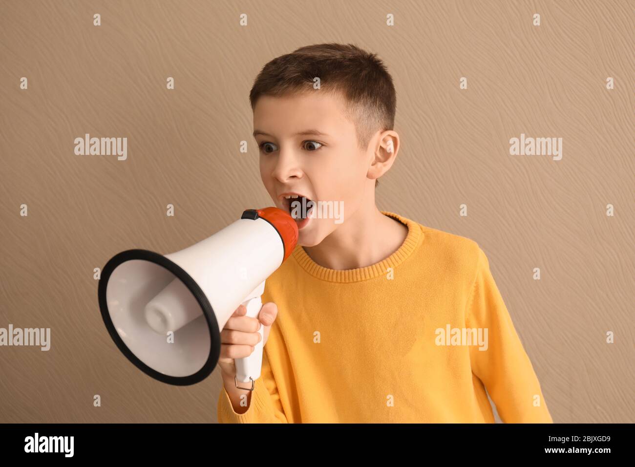 Emotional little boy with megaphone on color background Stock Photo - Alamy