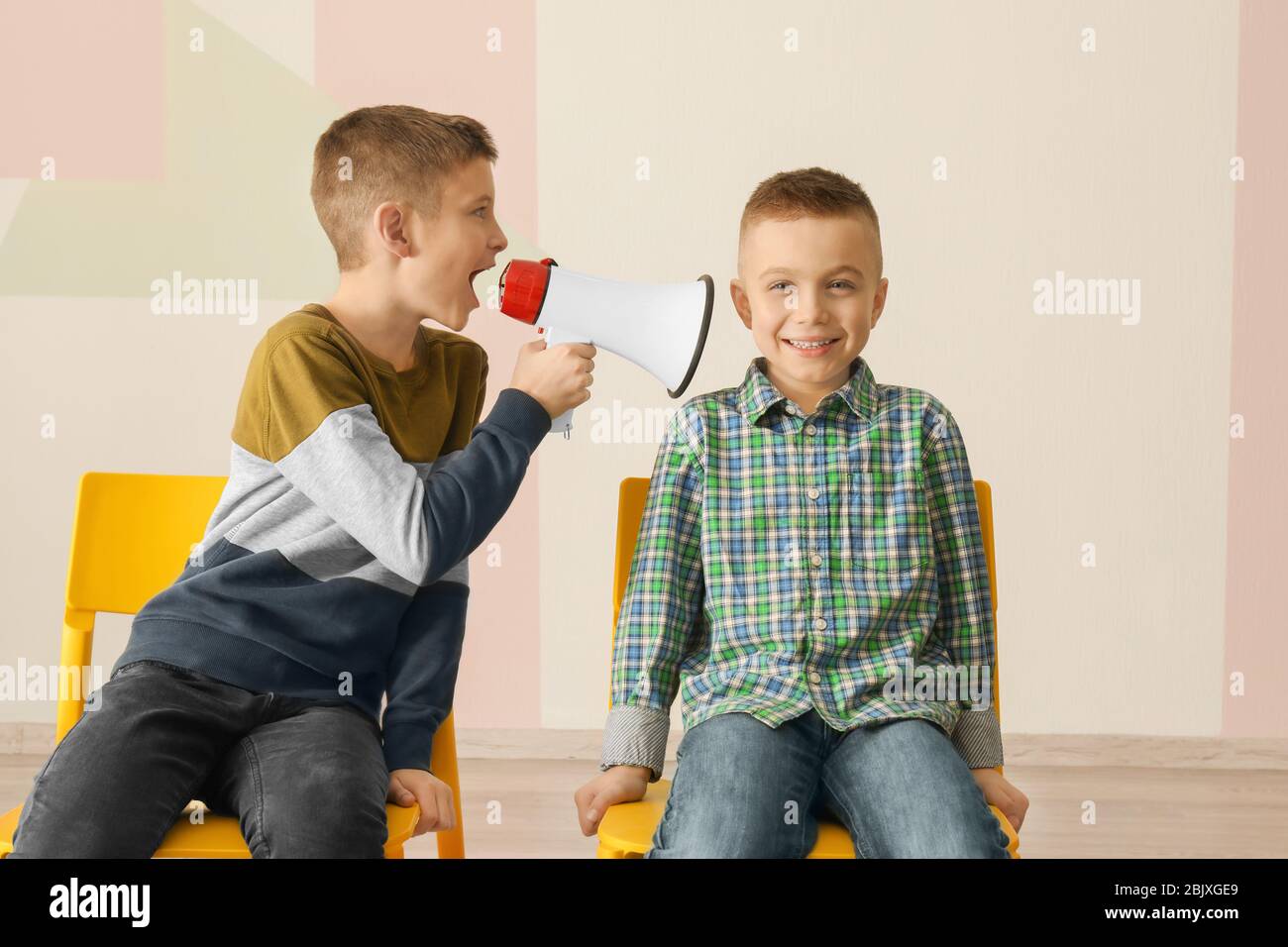 Funny little boy shouting at his friend using megaphone Stock Photo - Alamy