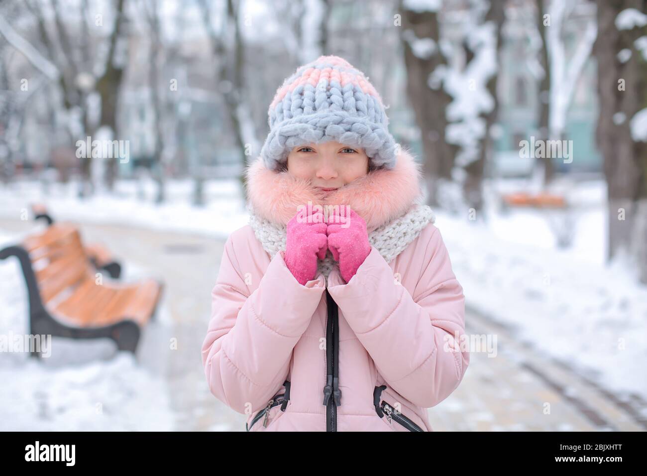Cute girl in cold snowy park on winter vacation Stock Photo - Alamy