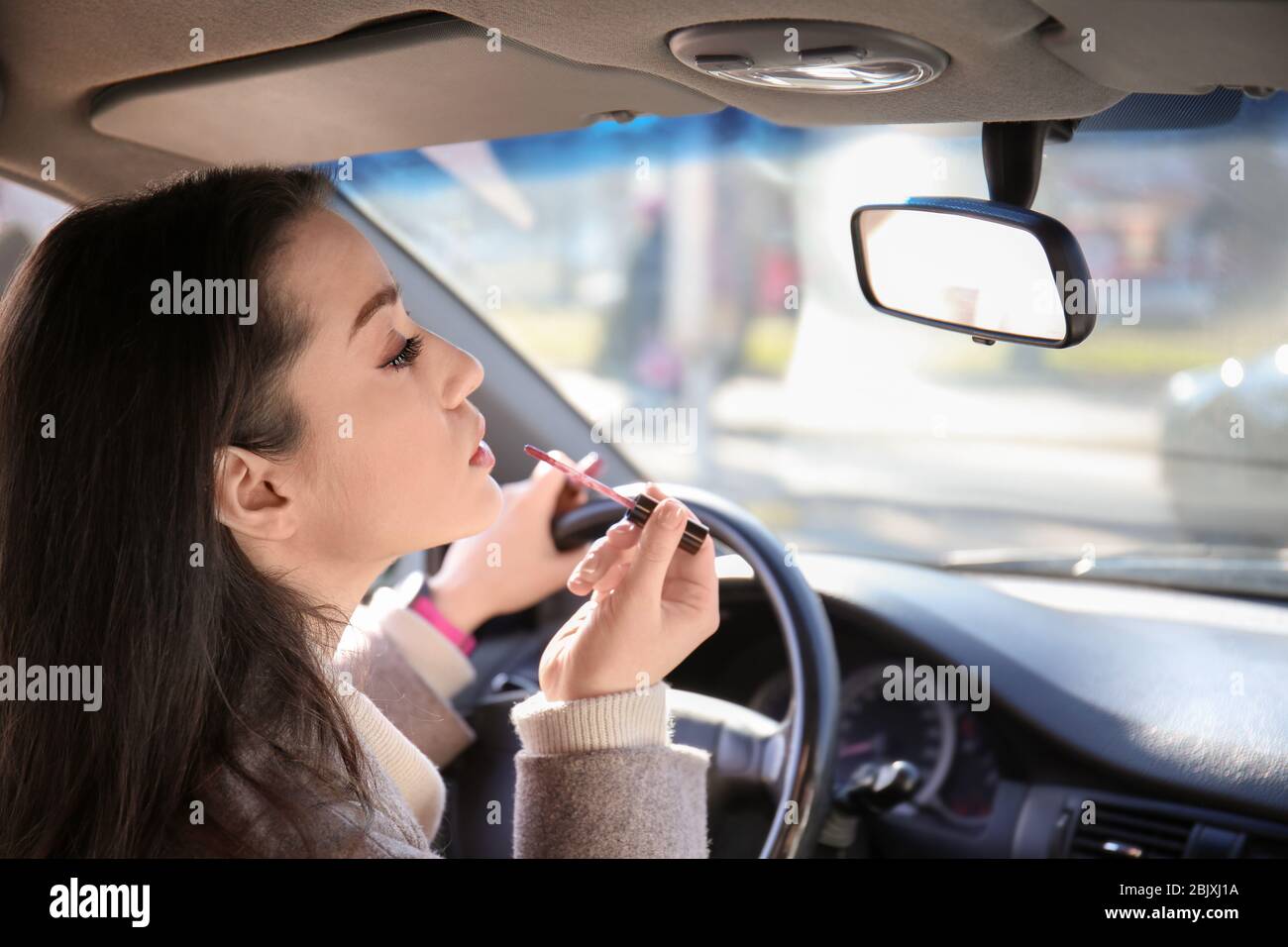 Young woman driving applying makeup hi-res stock photography and images ...