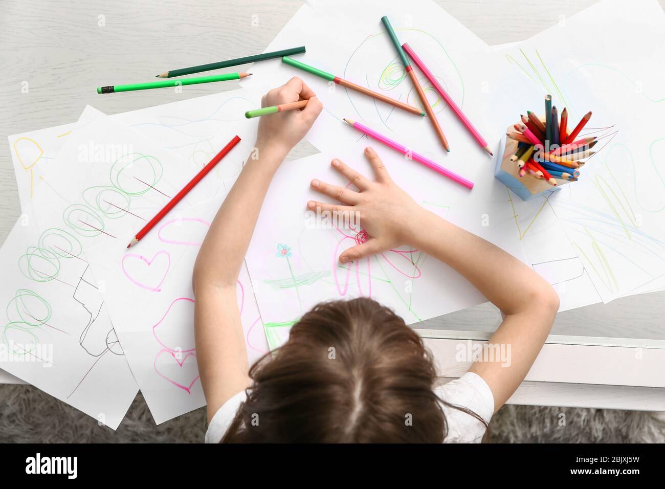 Cute little girl drawing at home, top view Stock Photo - Alamy