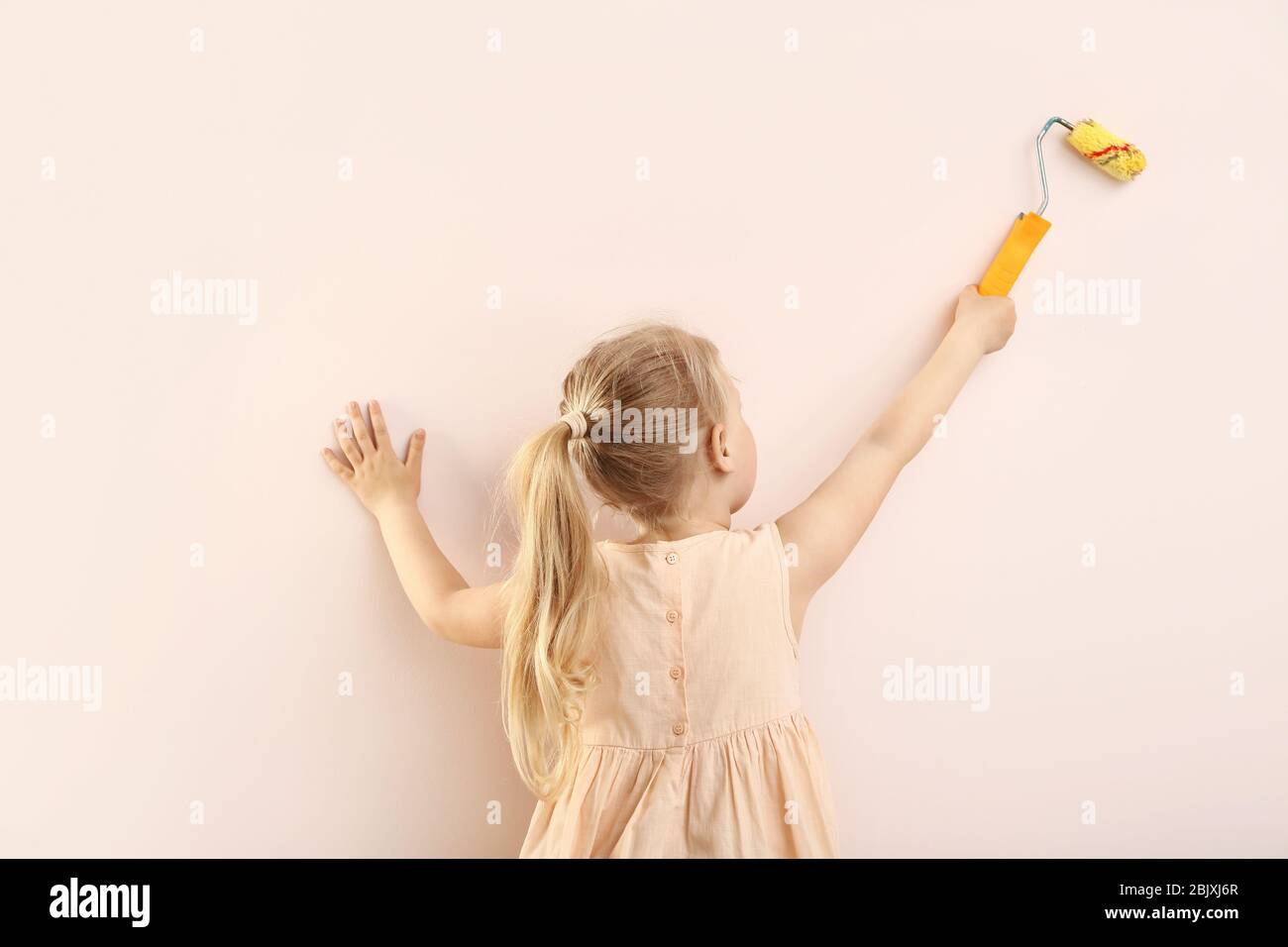 Little girl painting color wall Stock Photo - Alamy