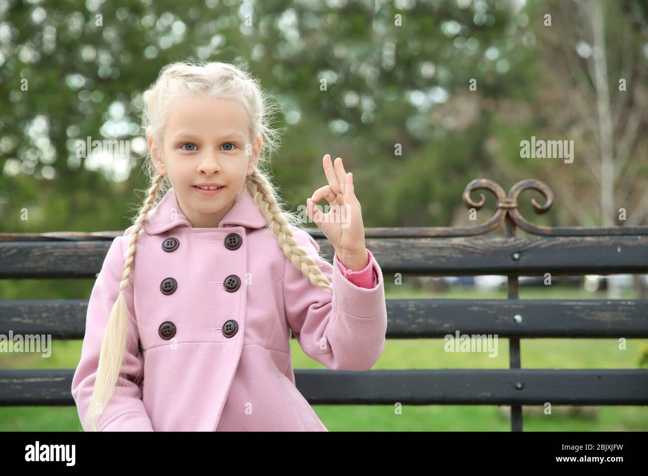 Little deaf mute girl using sign language outdoors Stock Photo - Alamy
