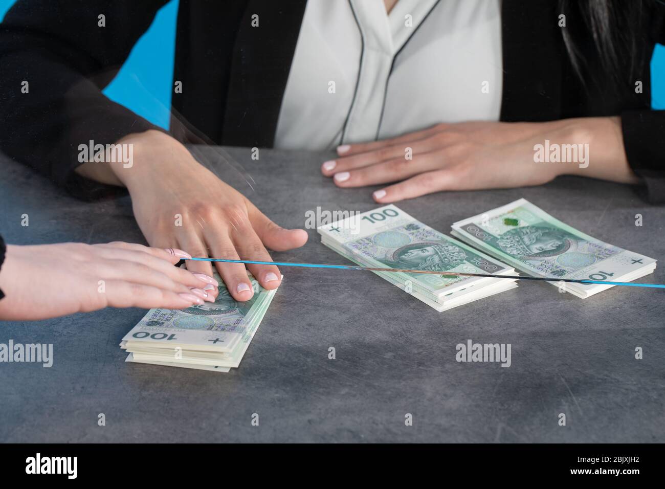 At a bank position, an employee accepts large sums of money from a ...