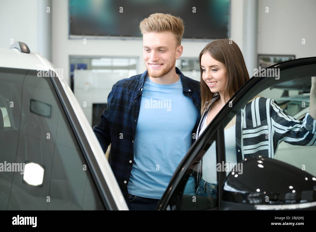 Couple choosing new car in salon Stock Photo - Alamy