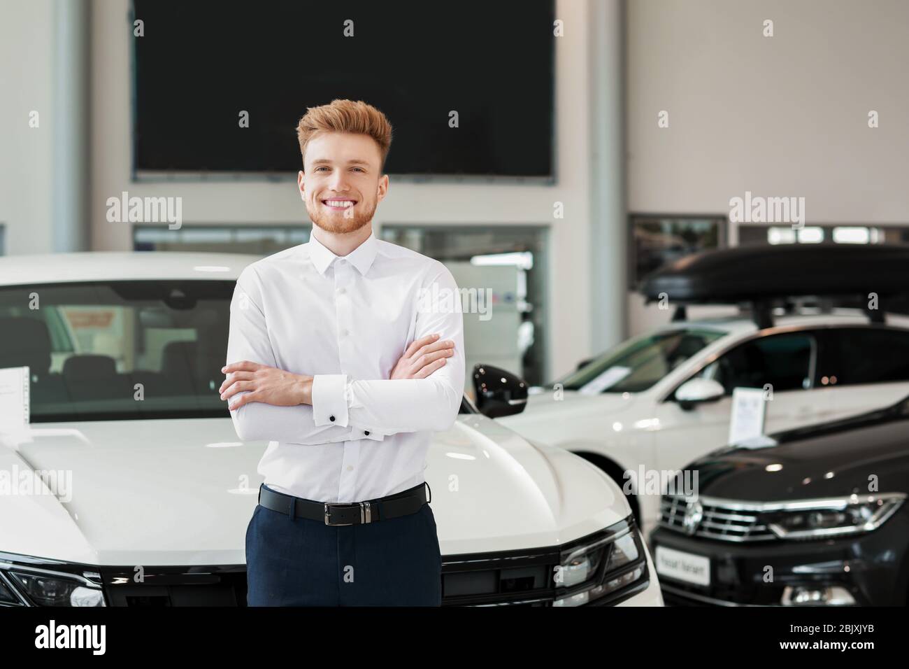 Salesman in modern car showroom Stock Photo - Alamy