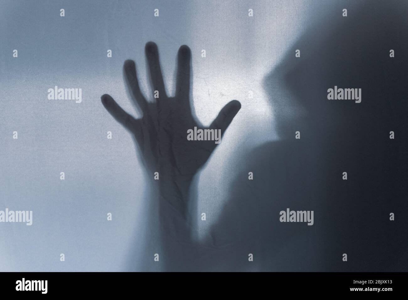 A mans hand shot through a semi transparent material. Creating a spooky ...
