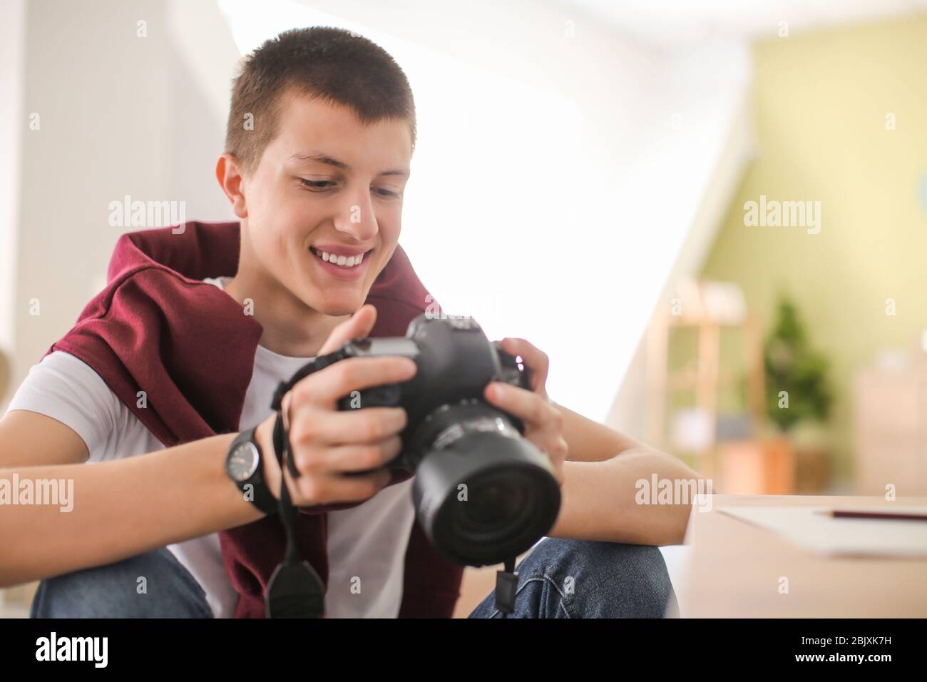 Teenage boy with photo camera at home Stock Photo - Alamy