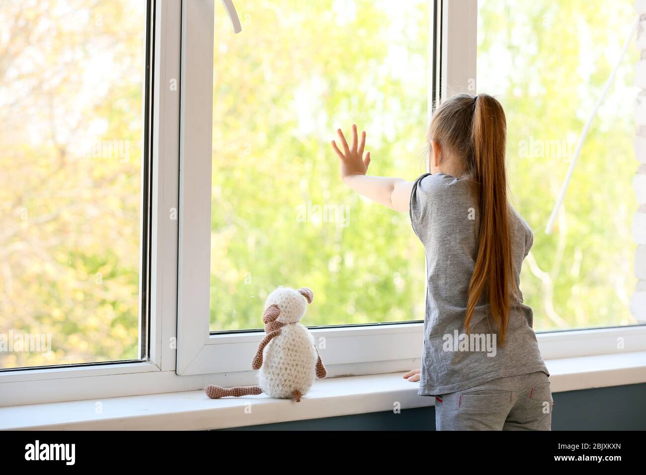 Little girl with autistic disorder near window at home Stock Photo - Alamy