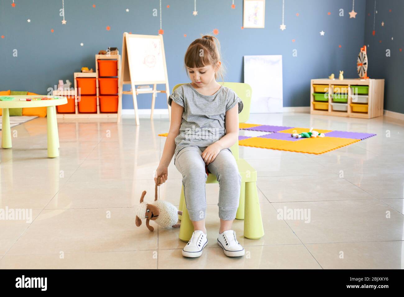 Sad little girl with autistic disorder in playroom Stock Photo - Alamy
