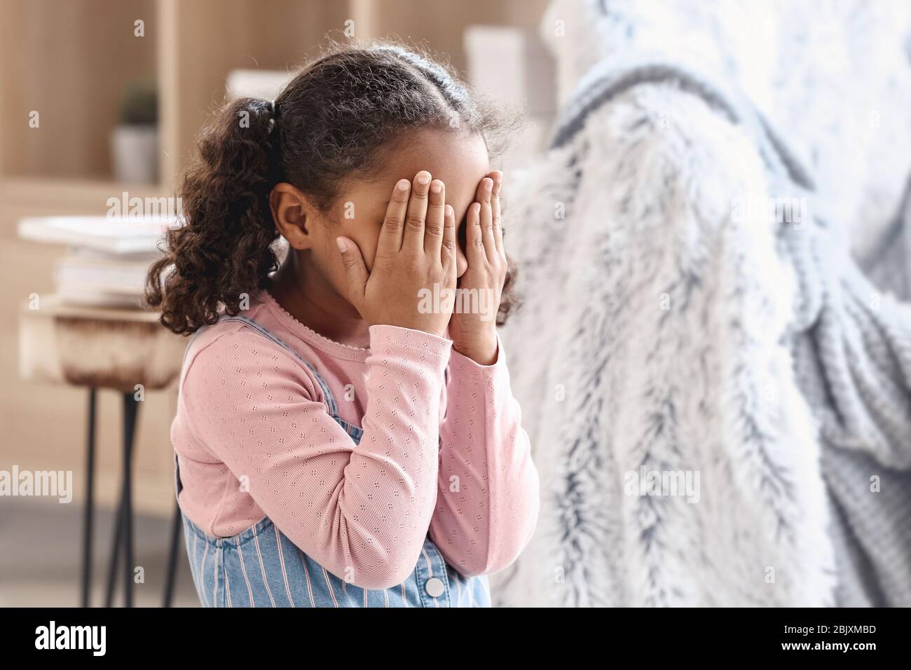 Crying little African-American girl at home Stock Photo - Alamy