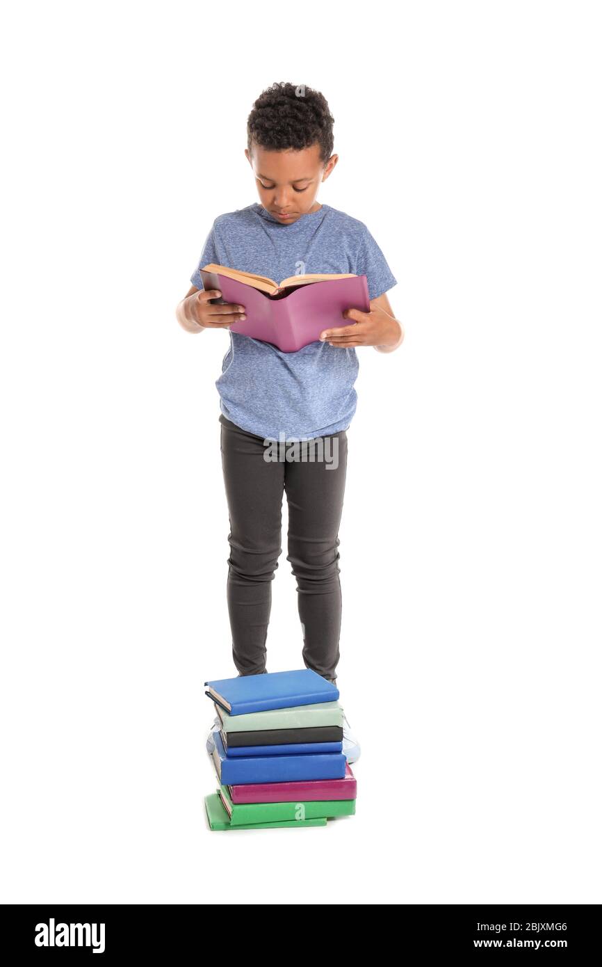 Cute African-American boy reading books on white background Stock Photo ...