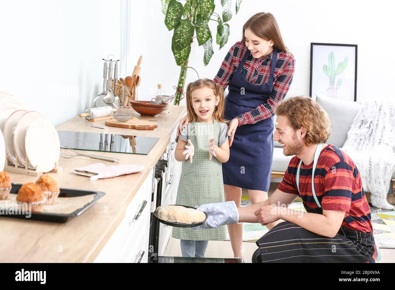 Happy family baking tasty cake at home Stock Photo - Alamy