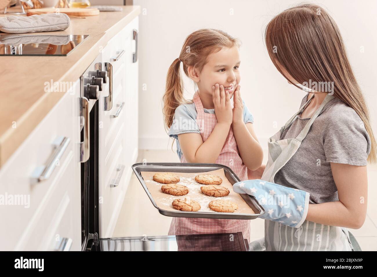 Little girl and her mother baking cookies in kitchen Stock Photo - Alamy