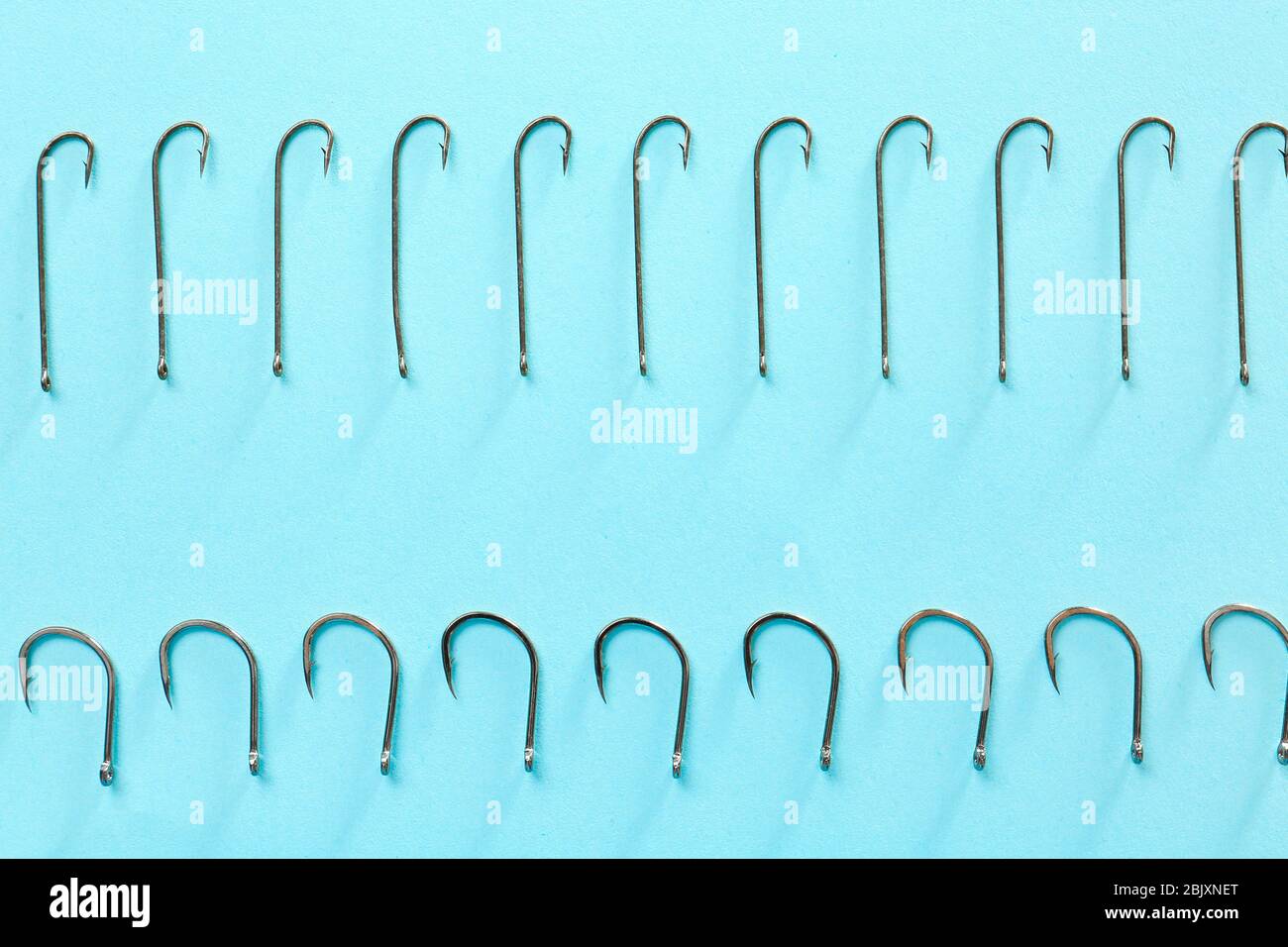 Different fishing hooks on color background Stock Photo - Alamy