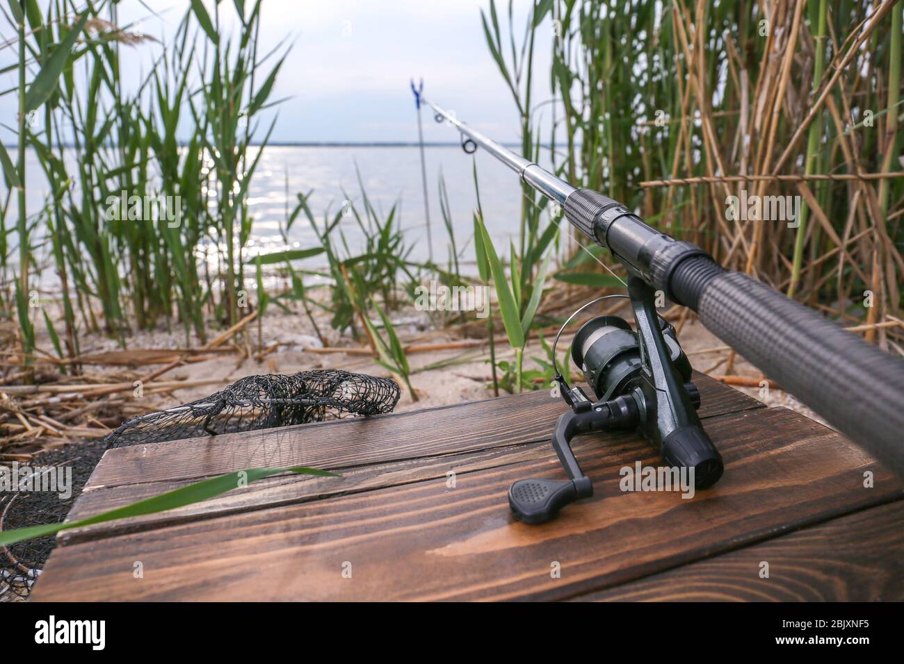 Modern fishing rod near river Stock Photo - Alamy
