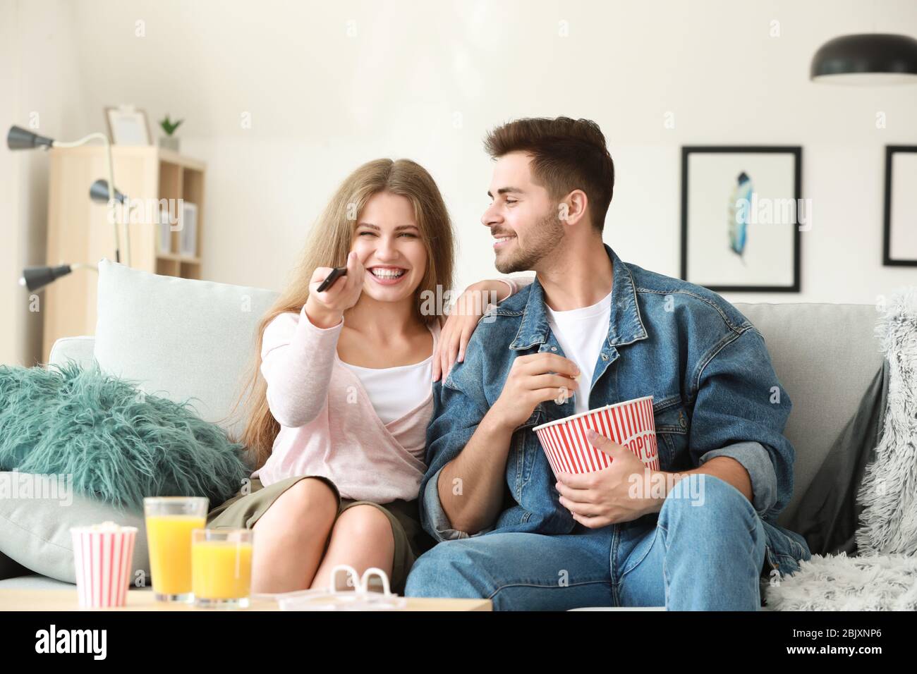 Happy couple watching TV at home Stock Photo - Alamy