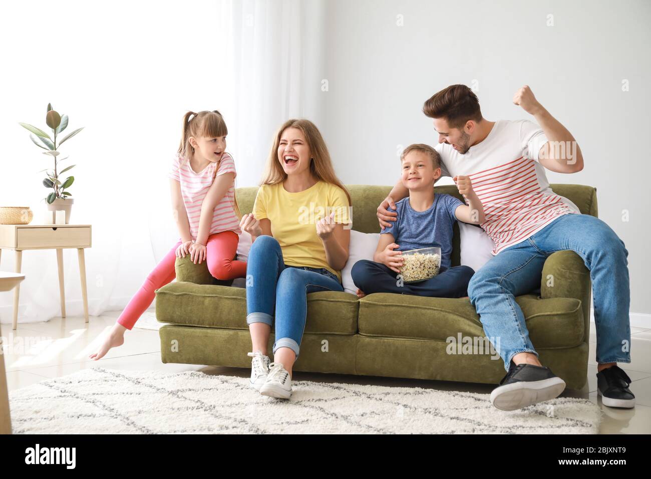 Happy family watching sports on TV at home Stock Photo - Alamy