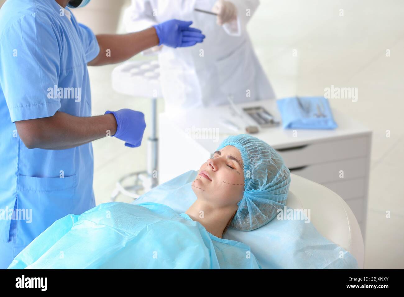 Plastic surgeon preparing woman for operation in clinic Stock Photo - Alamy
