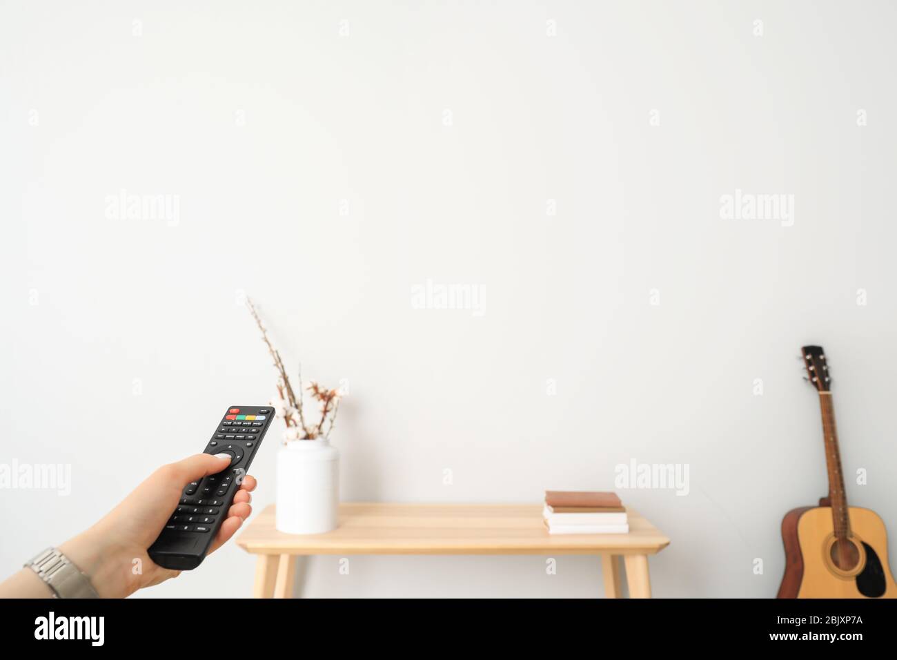 Woman with remote control at home Stock Photo - Alamy
