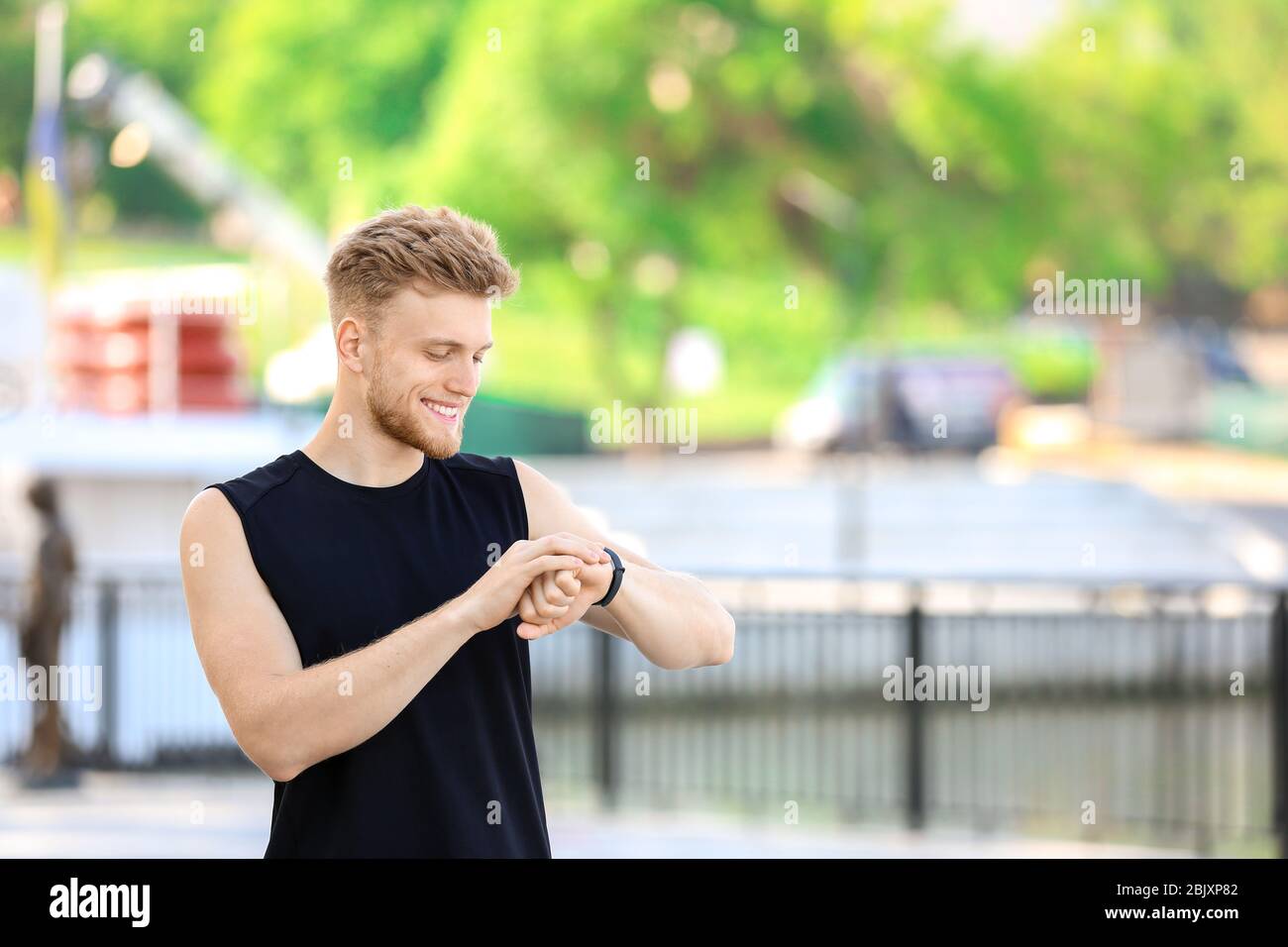 Sporty young man checking his pulse outdoors Stock Photo - Alamy